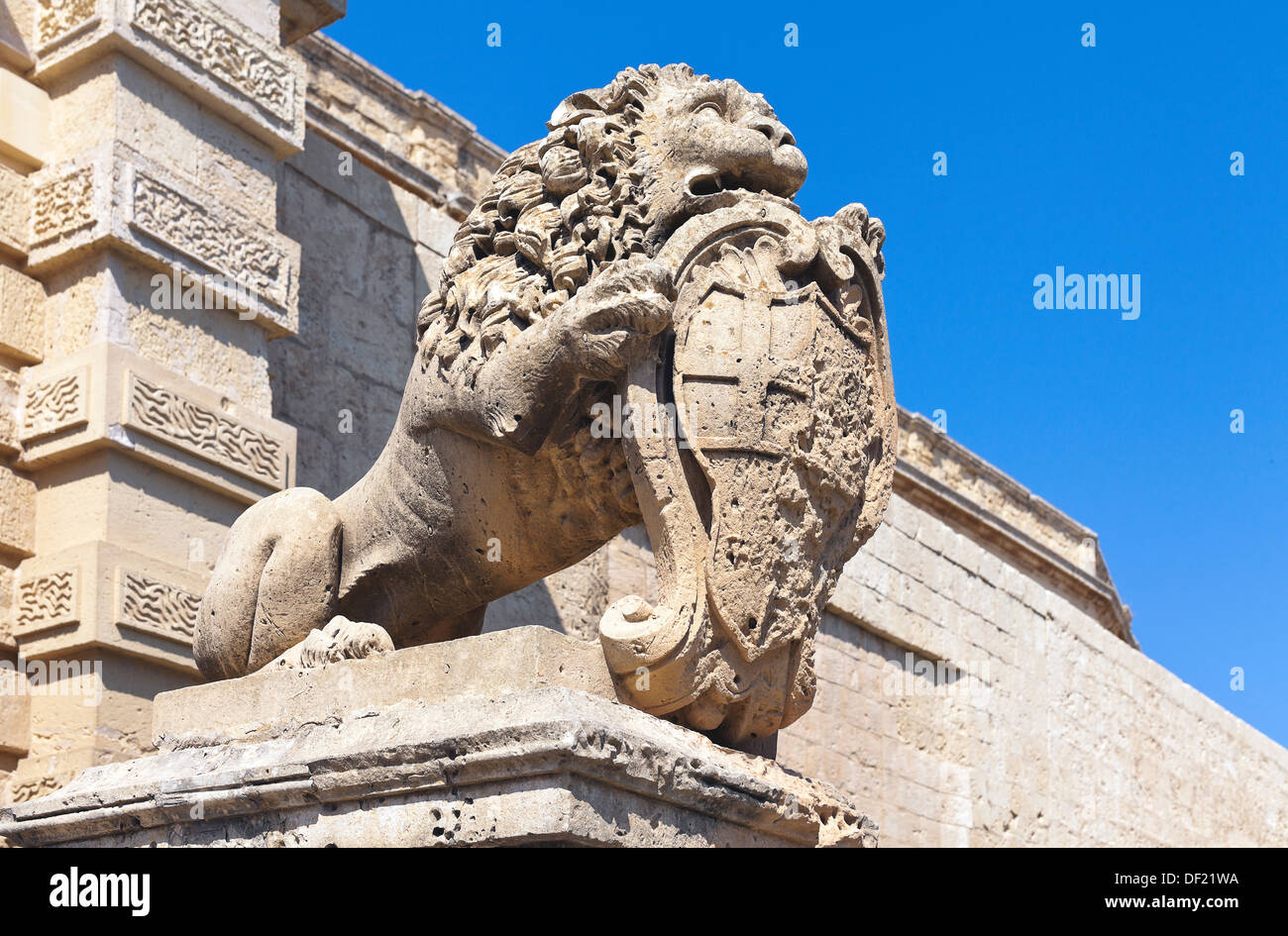 Stone lion statue holding shield outside castle wall Stock Photo - Alamy
