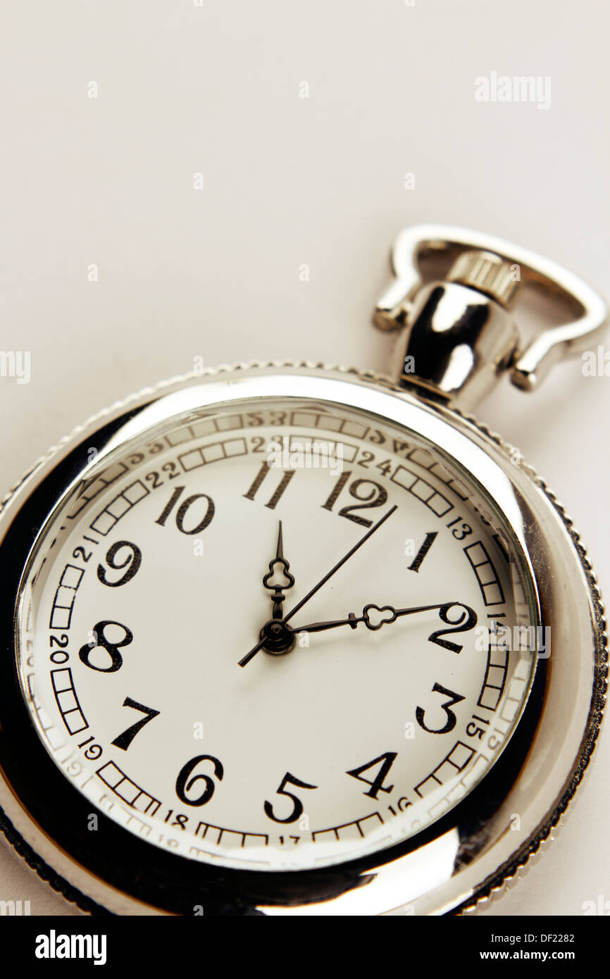 Pocket watch on plain background Stock Photo - Alamy