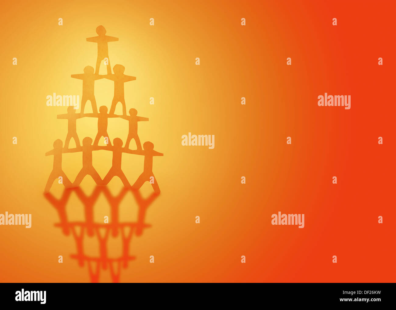 Human team pyramid on orange background Stock Photo - Alamy