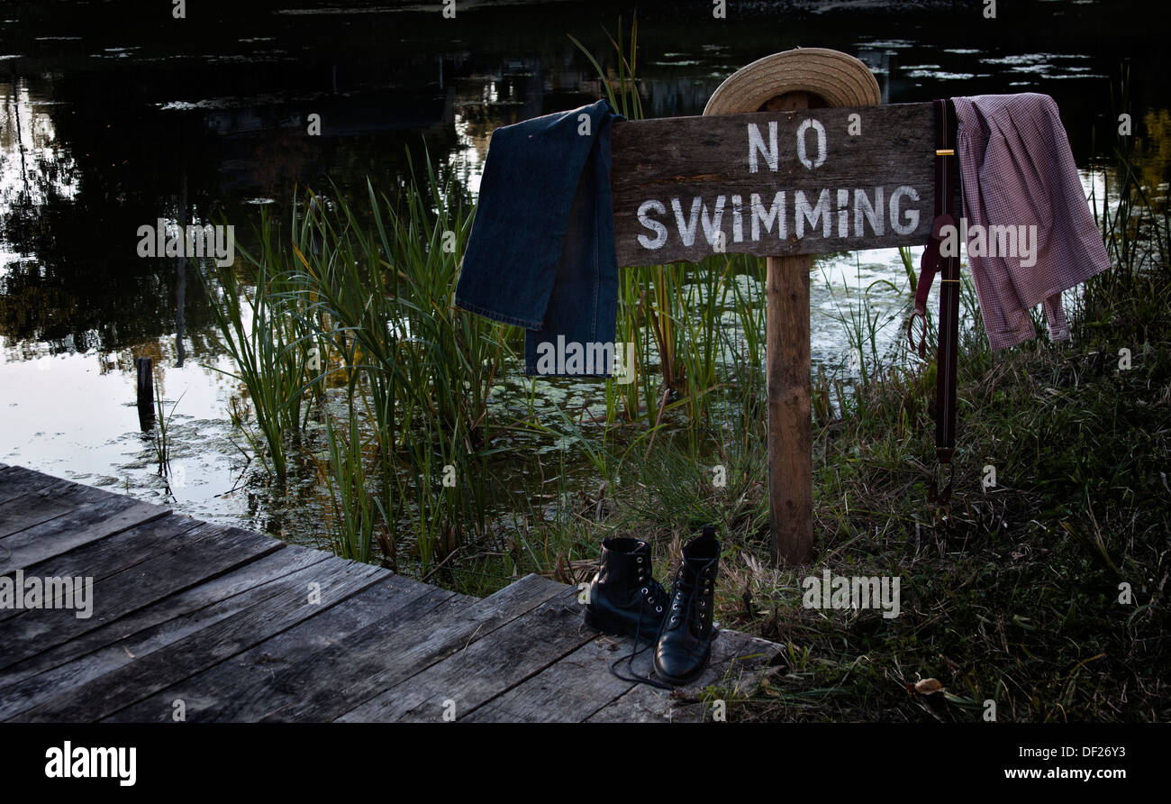 NO Swimming sign by a pond with vintage clothes hanging from sign Stock ...