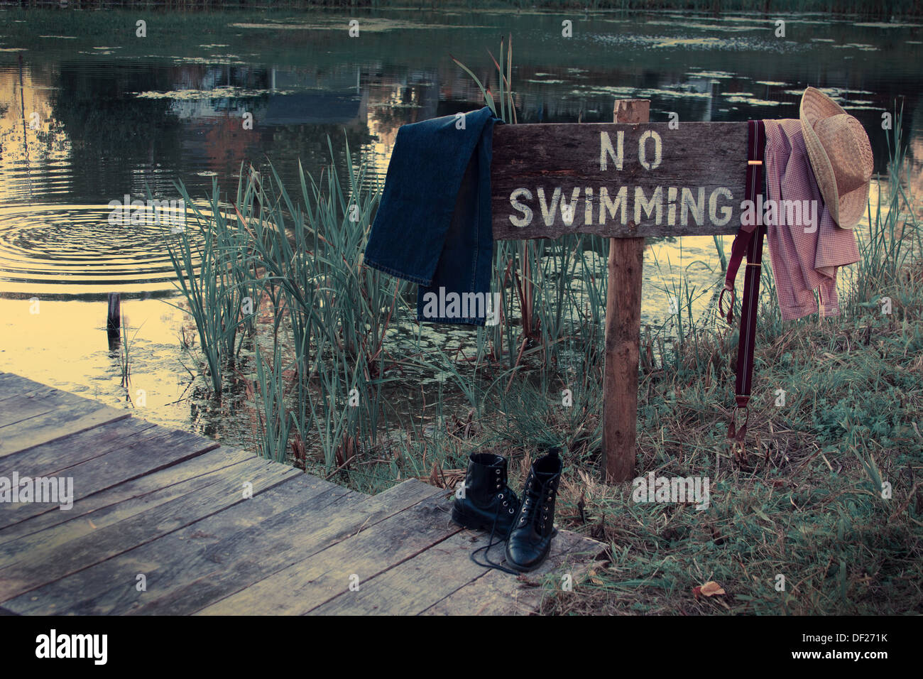 NO Swimming sign by a pond with vintage clothes hanging from sign Stock ...