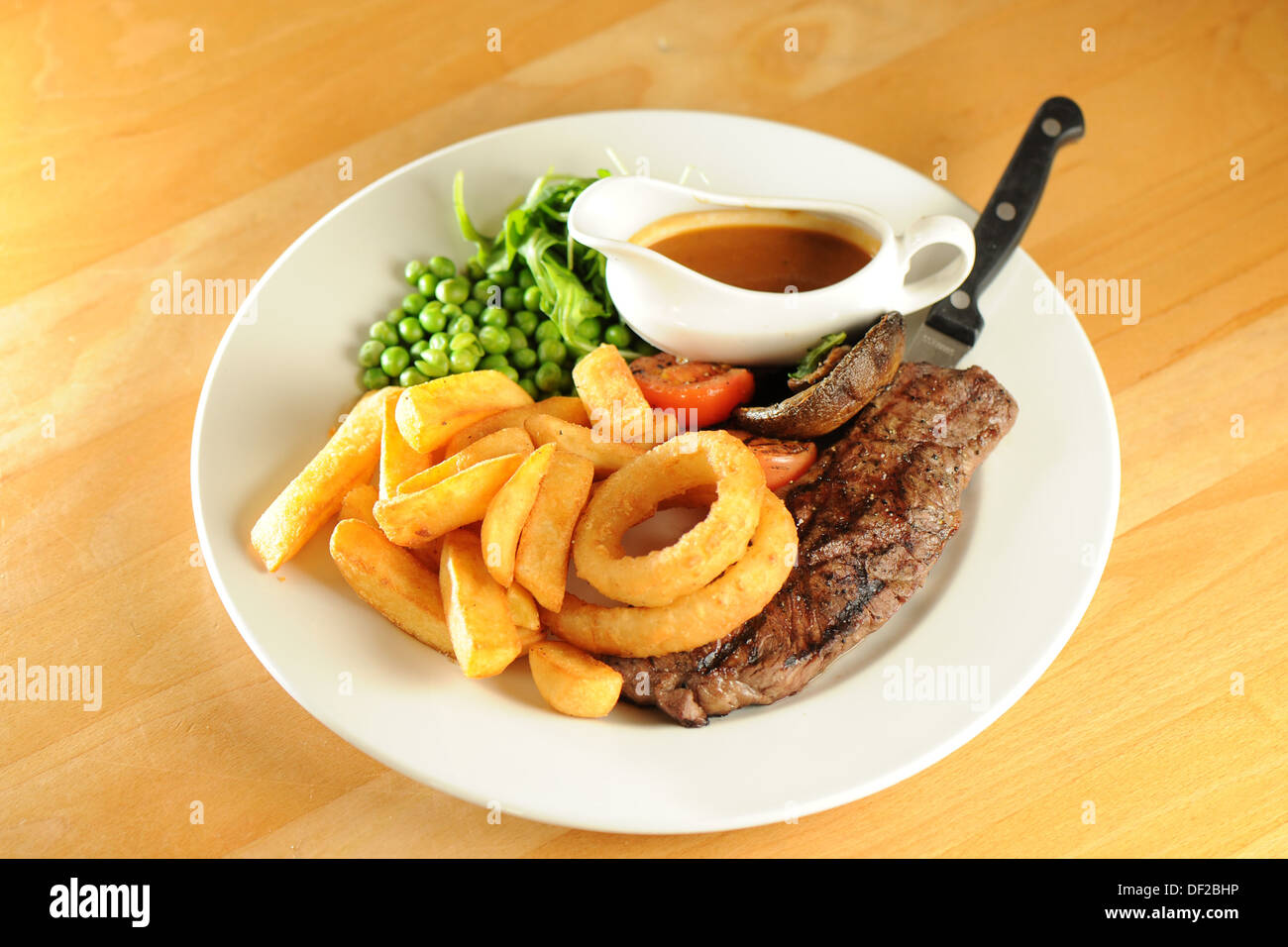 Traditional pub food - sirloin steak, onion rings and peas Stock Photo ...