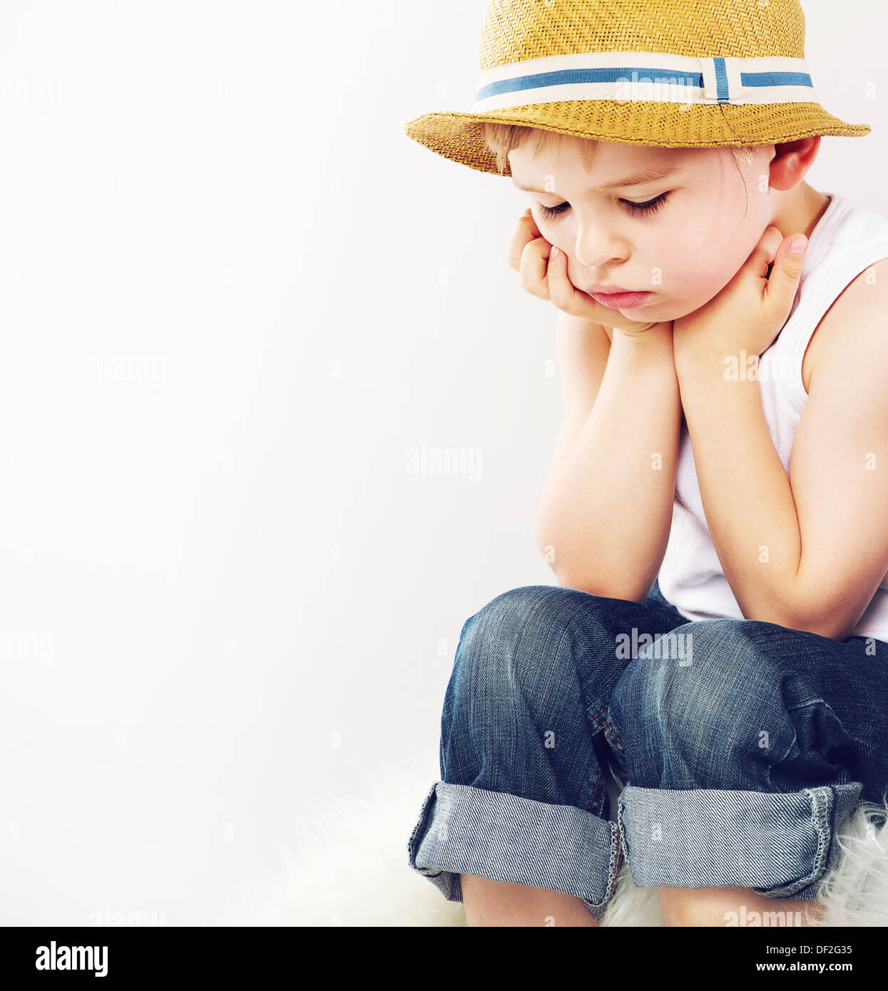 Sad cute boy with his straw hat Stock Photo - Alamy