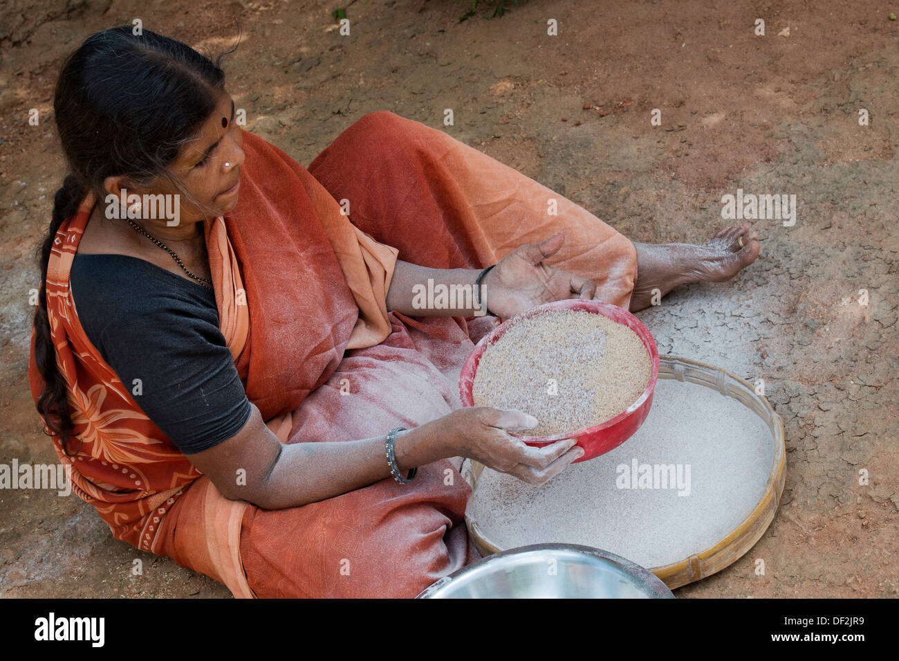Rural Indian village woman sifting Finger Millet flour / Ragi flour ...
