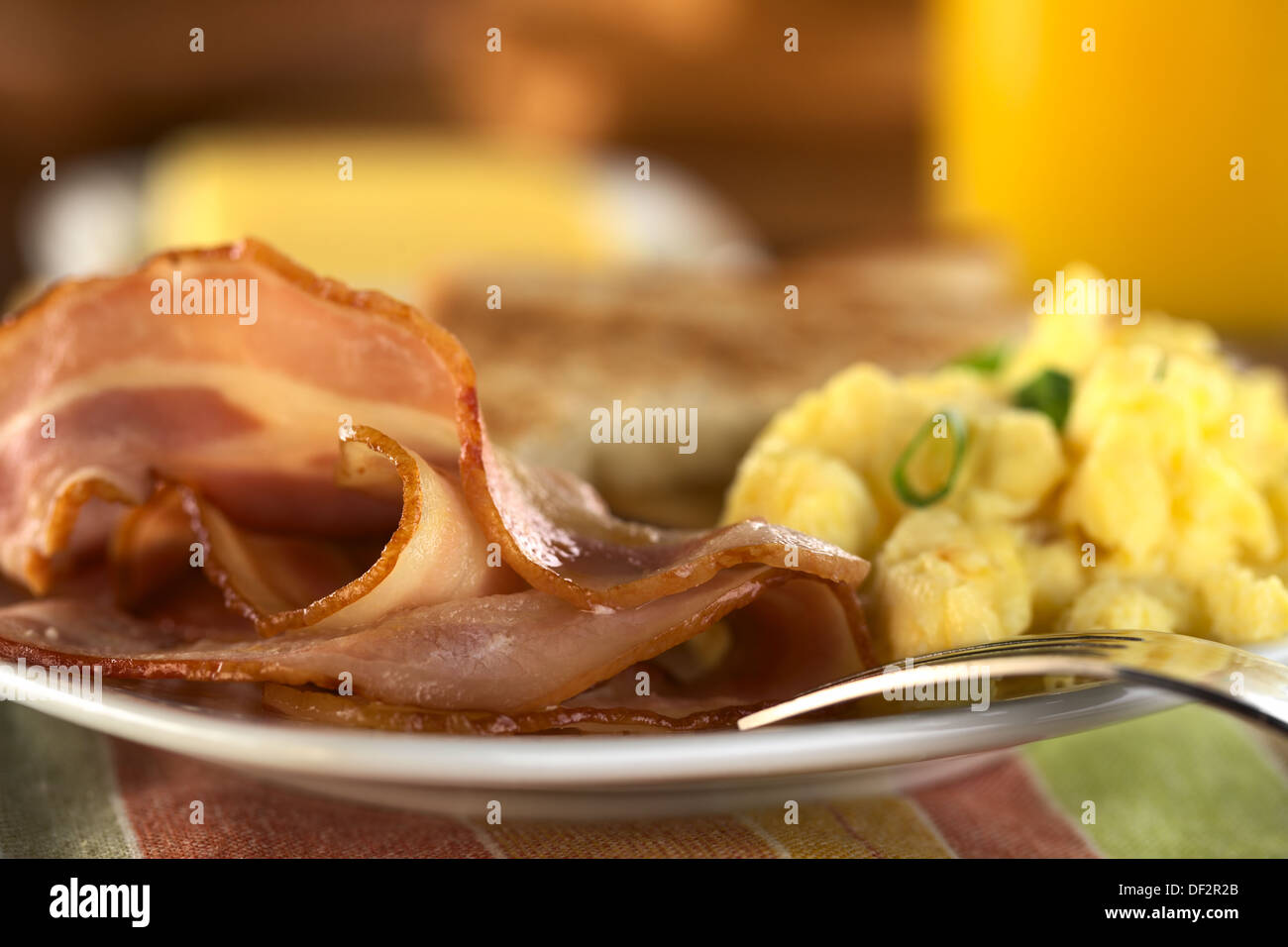 Fried bacon and scrambled eggs with toast bread and orange juice in the ...