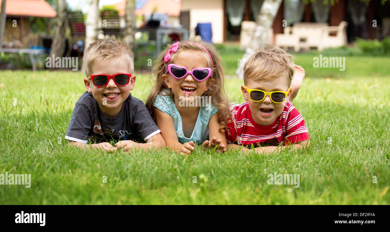 Happy laughing children lying on the grass Stock Photo - Alamy