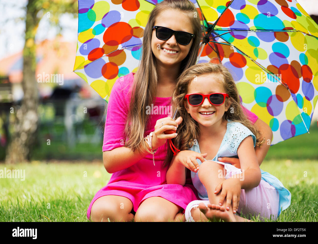 Two cute sisters smiling to the camera Stock Photo - Alamy