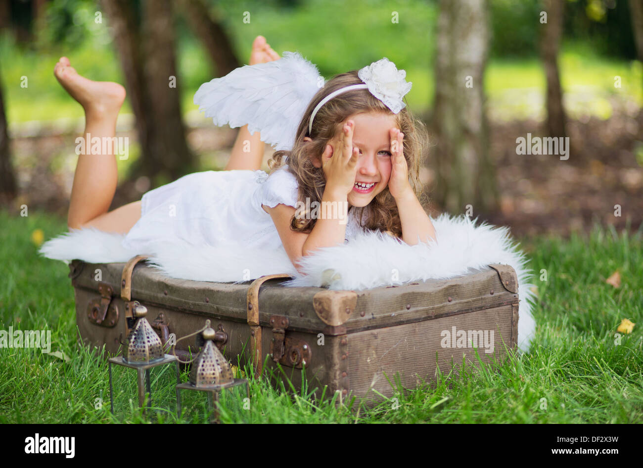 Small cute angel hiding her face behind the hands Stock Photo - Alamy