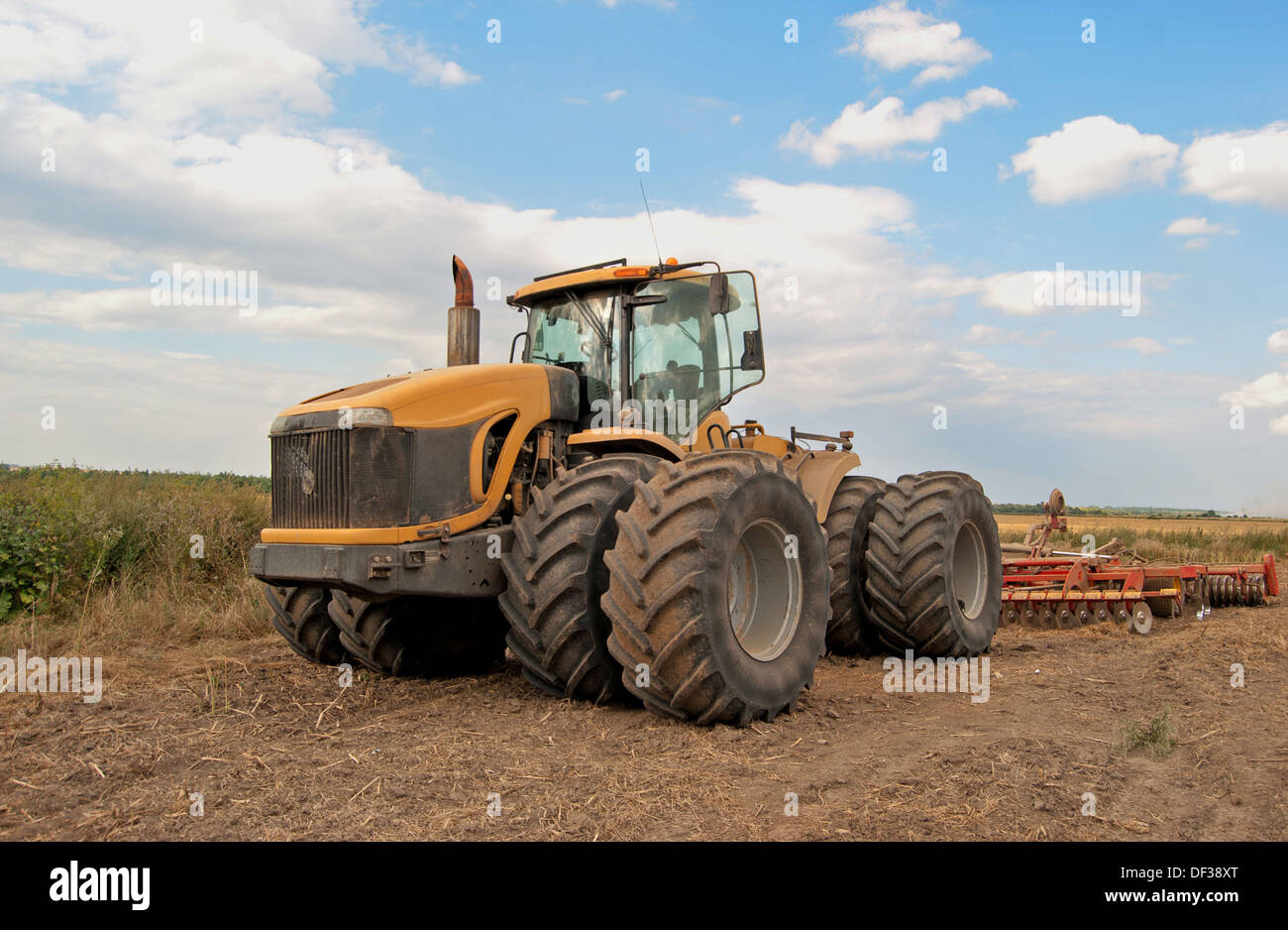 a large yellow tractor processes the field Stock Photo - Alamy