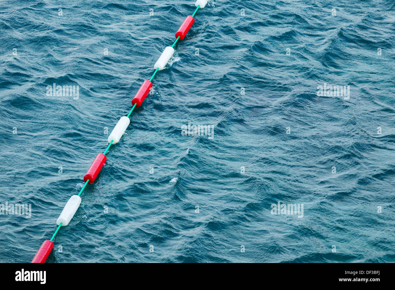 Border of swimming area marked with line of red and white plastic buoys ...