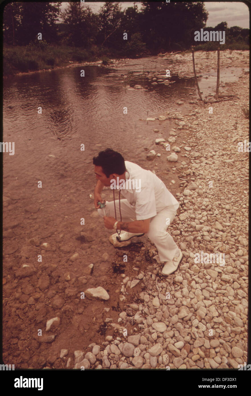 A LOCAL HEALTH OFFICER TAKING A WATER SAMPLE FROM THE FRIO RIVER NEAR ...
