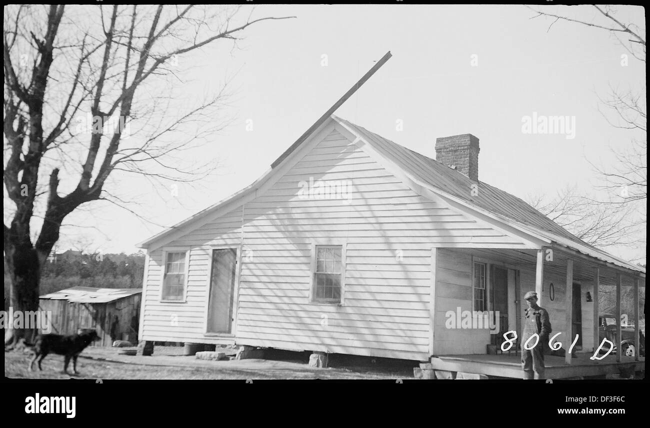 A photograph of George Beason standing in front of his home, captured ...