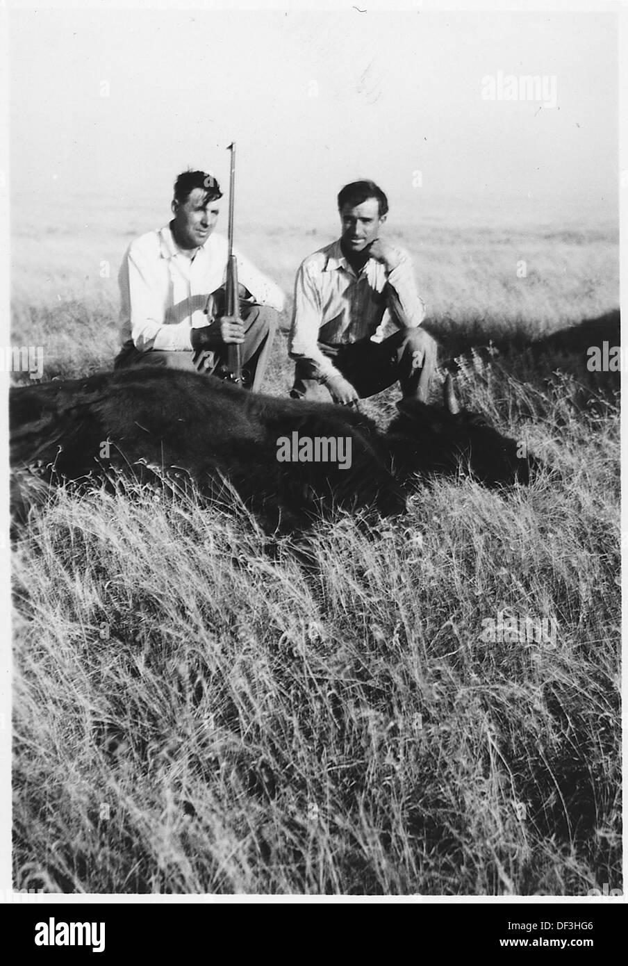 A historical image of buffalo hunters with their prey, capturing an ...