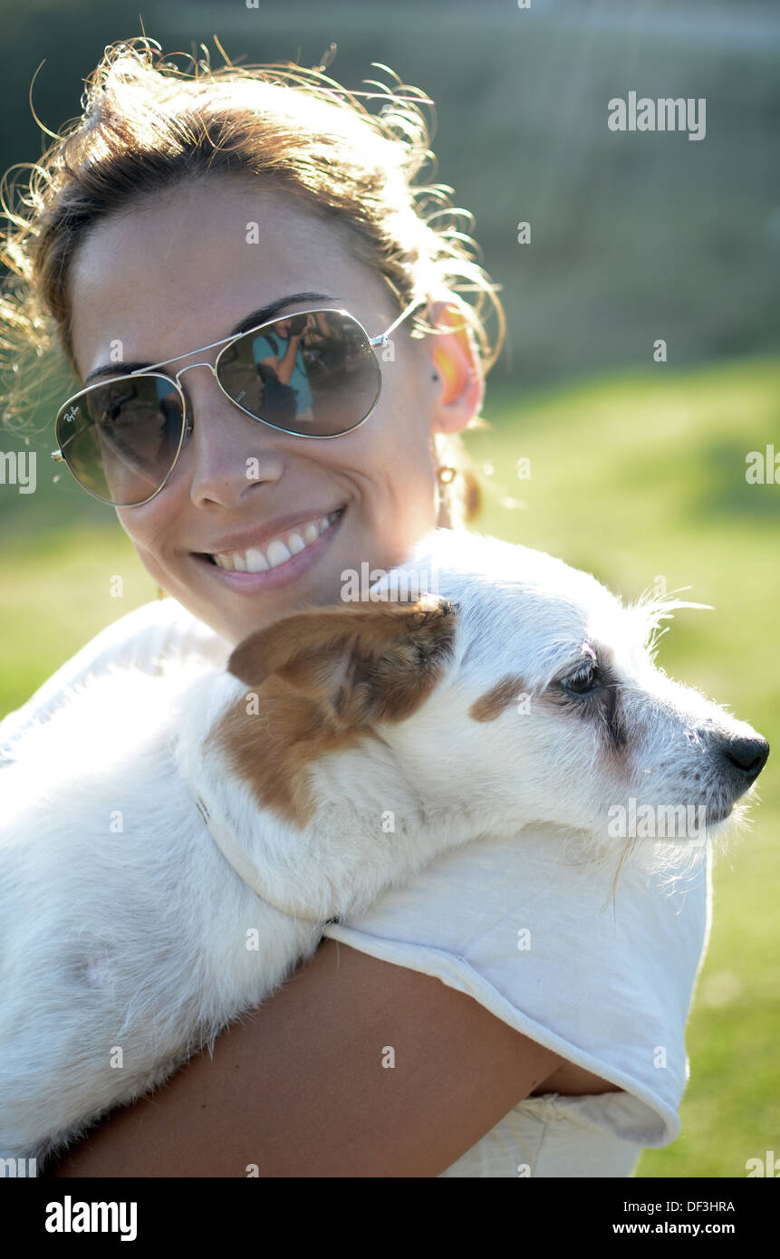 Attractive young woman poses with her small white dog Stock Photo - Alamy