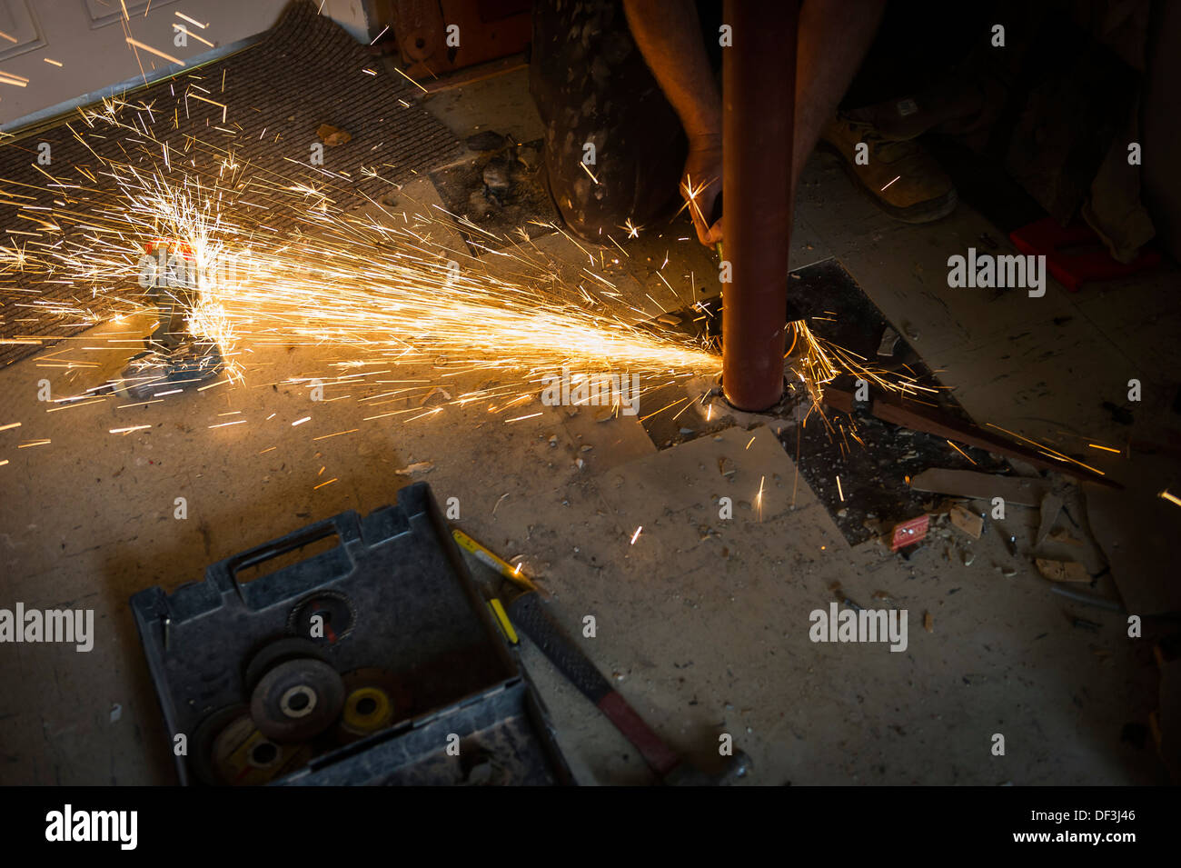 A construction worker using an angle grinder to cut a metal pipe Stock ...