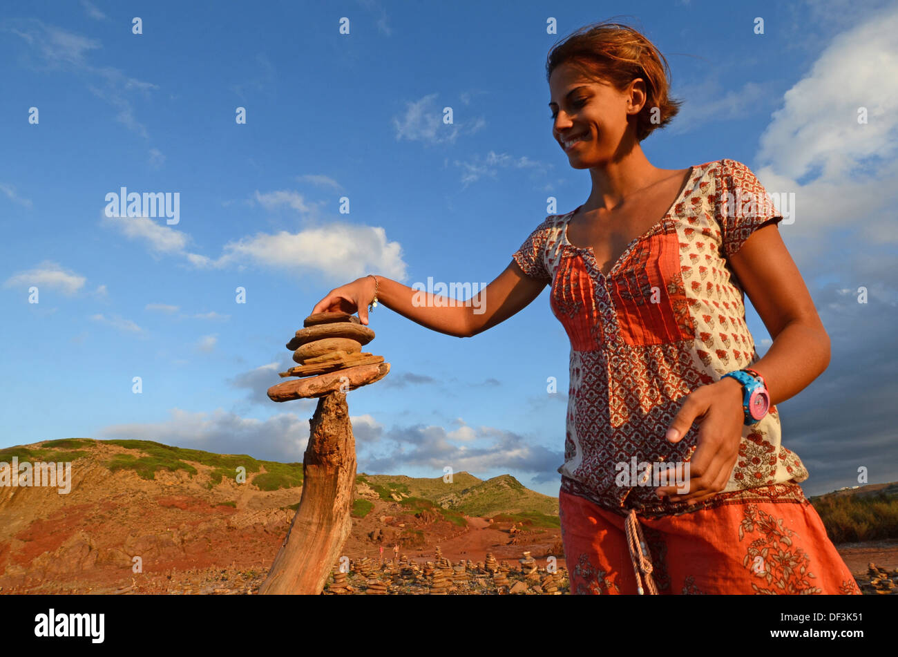 Young woman building a stone sculpture in Cala Pregonda, Menorca Stock ...