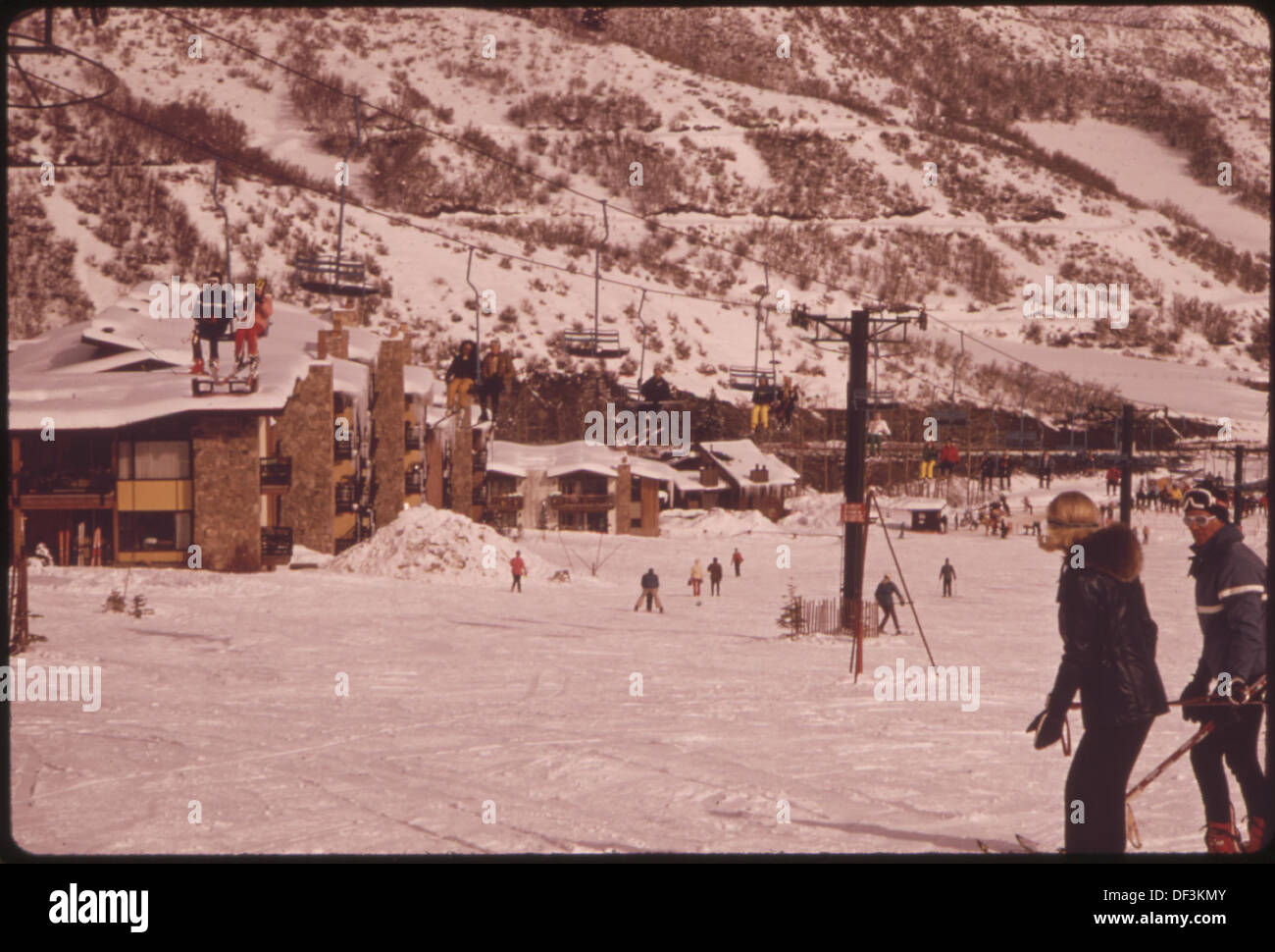 A chairlift at Snowmass Mountain passes by condominiums built alongside ...