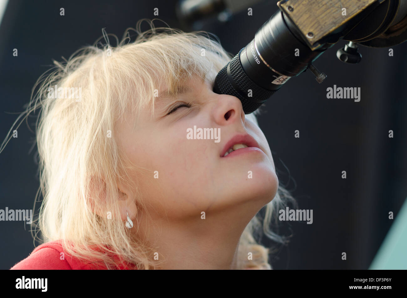 young girl looking through telescope, observing space objects Stock ...