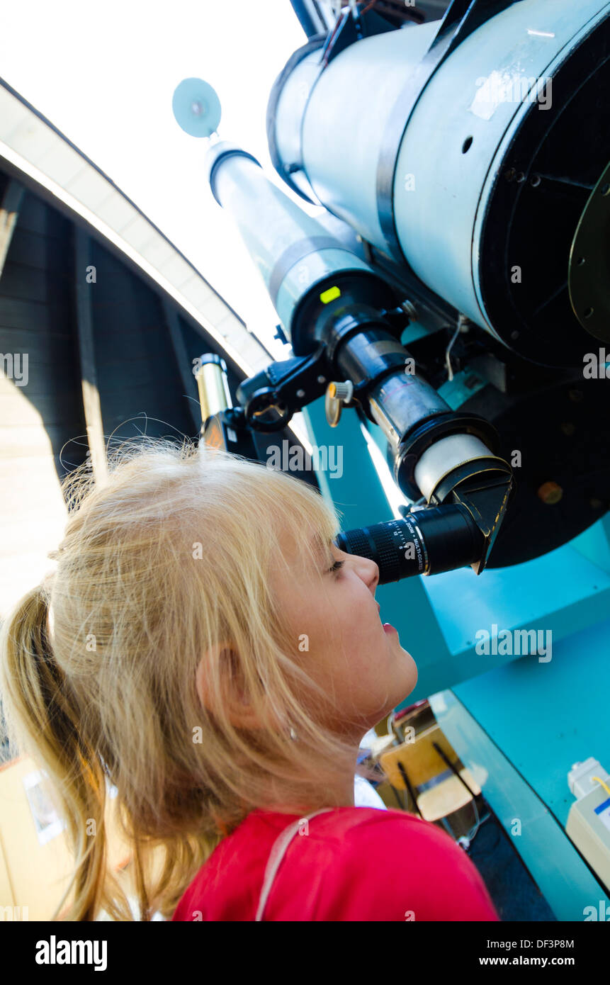 young girl looking through telescope, observing space objects Stock ...
