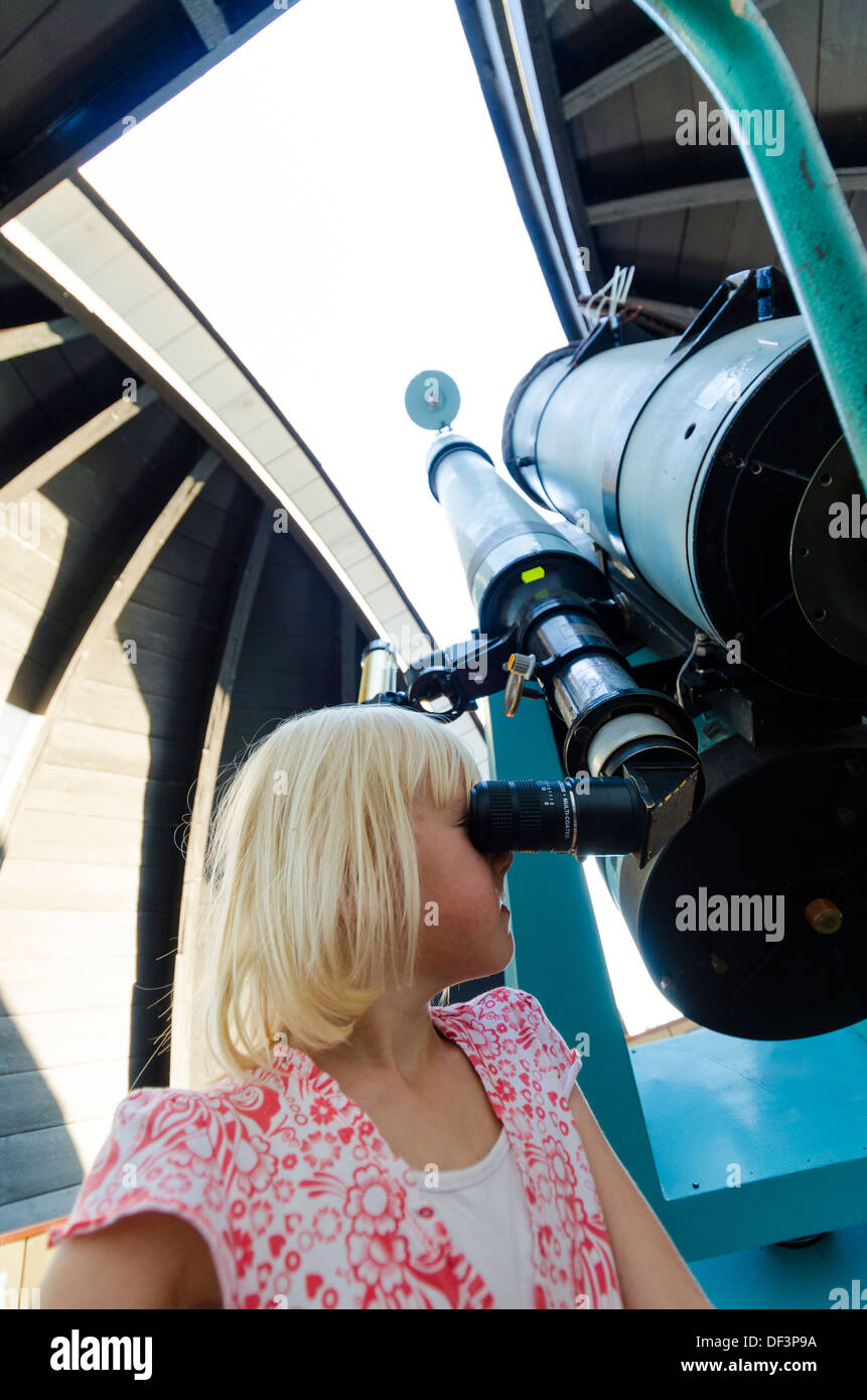 young girl looking through telescope, observing space objects Stock ...