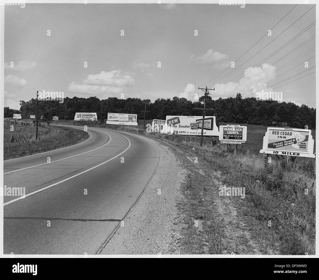 This image shows a curve in a highway lined with various billboards ...