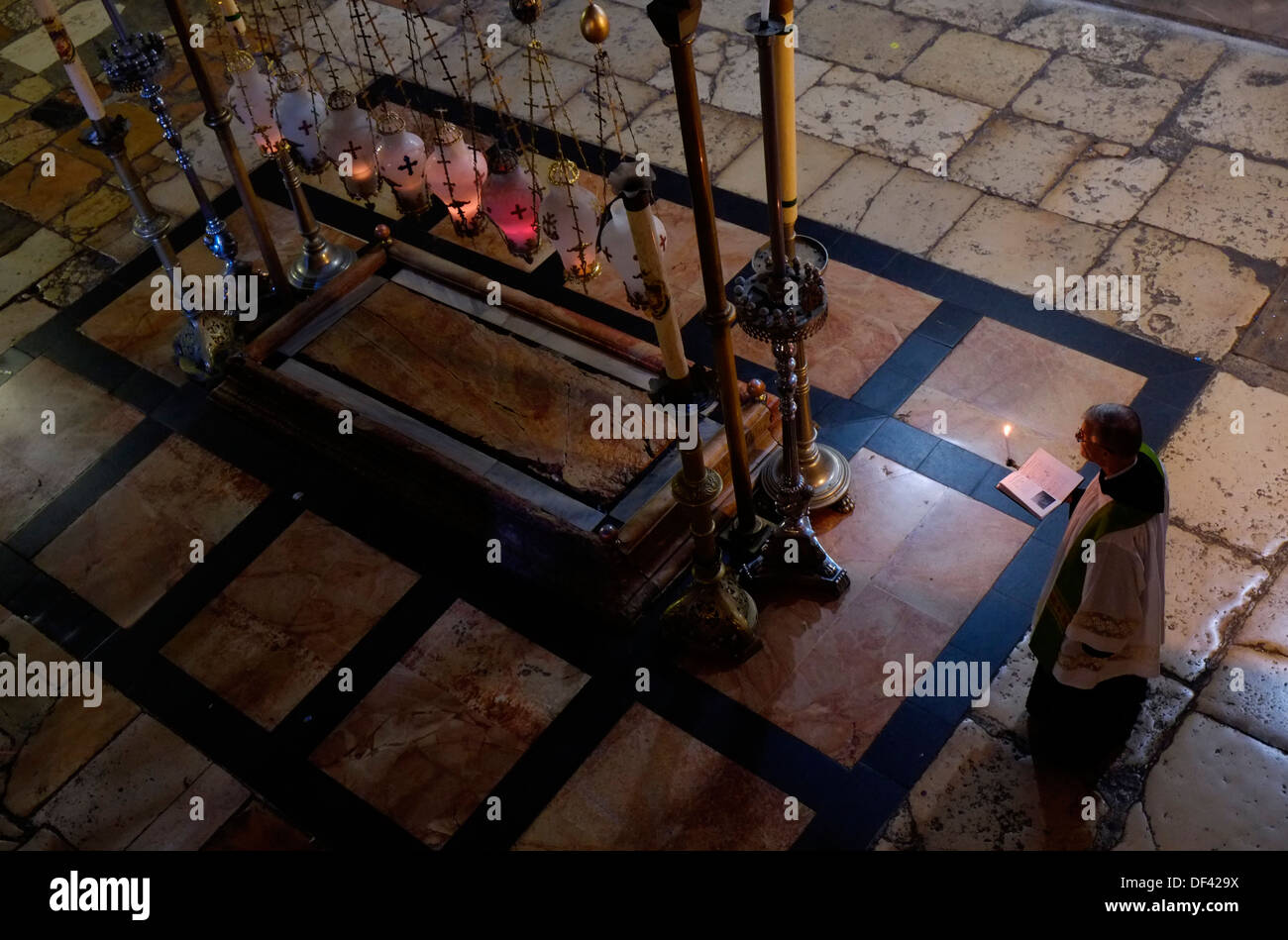 A Franciscan friar praying at the Stone of the Anointing or Stone of ...