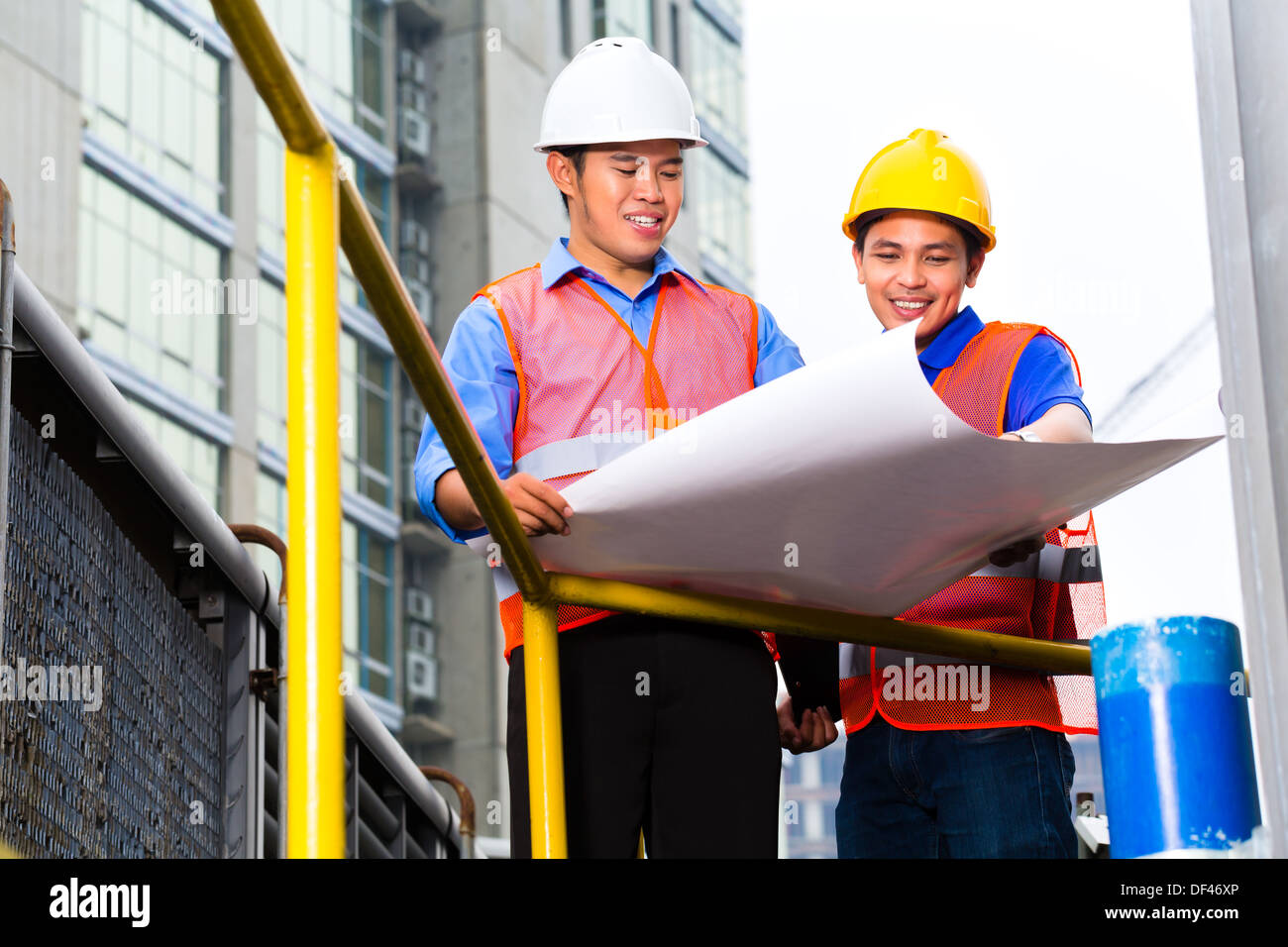 Chinese architect and supervisor point on building site on a ...