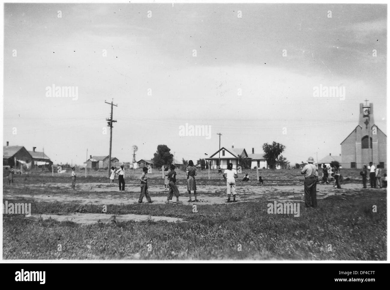 Group of Indian children playing baseball, village in background ...