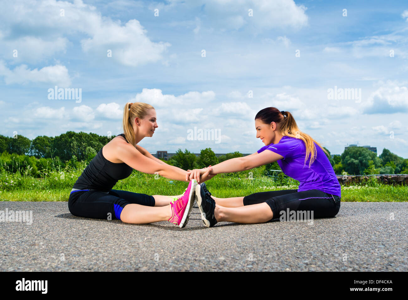 Urban sports - young women doing warming up together before running in ...