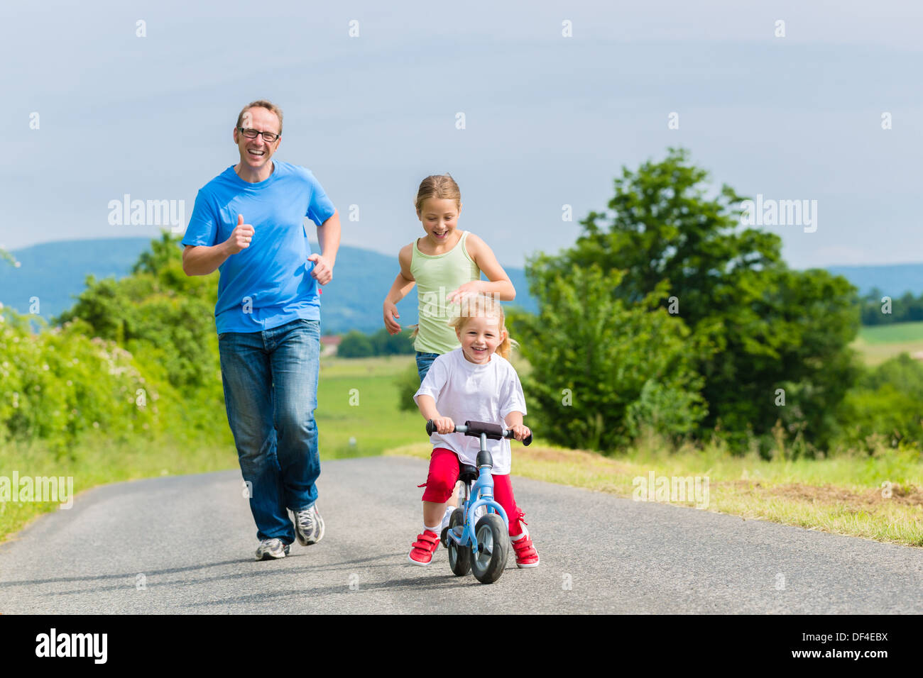 Family activity - Little girl and their father or dad running on street ...