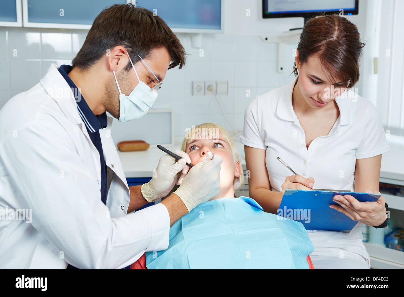 Dental assistant during apprenticeship taking notes while dentist ...