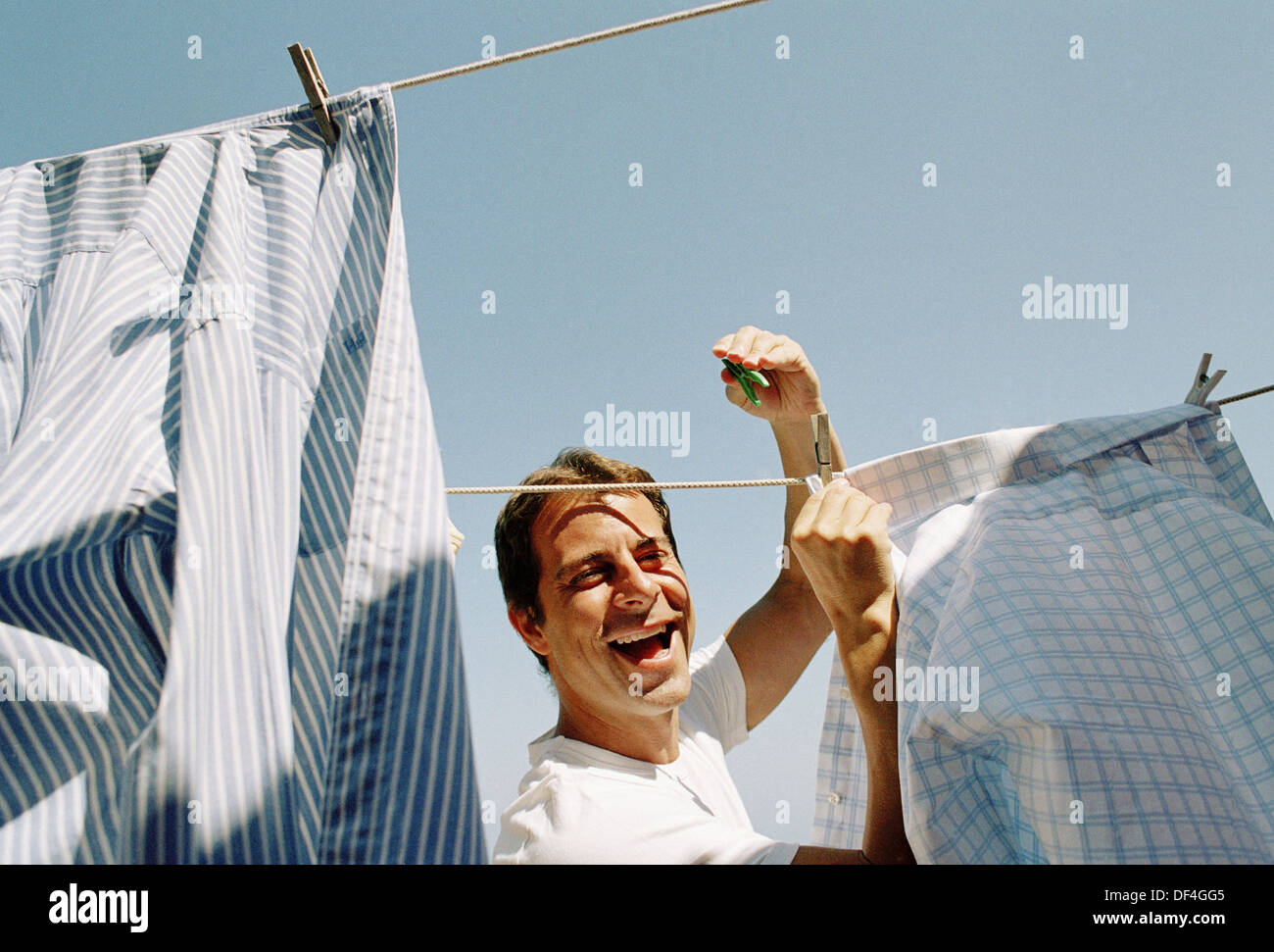 Man hanging up washing hi-res stock photography and images - Alamy