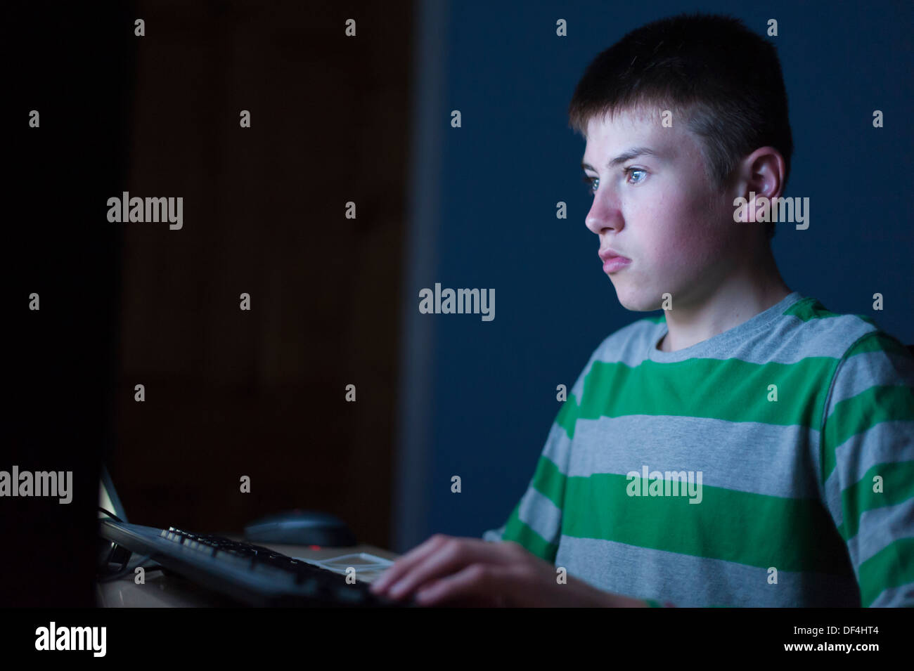 A 13 year old boy looking at his computer screen in his bedroom Stock ...