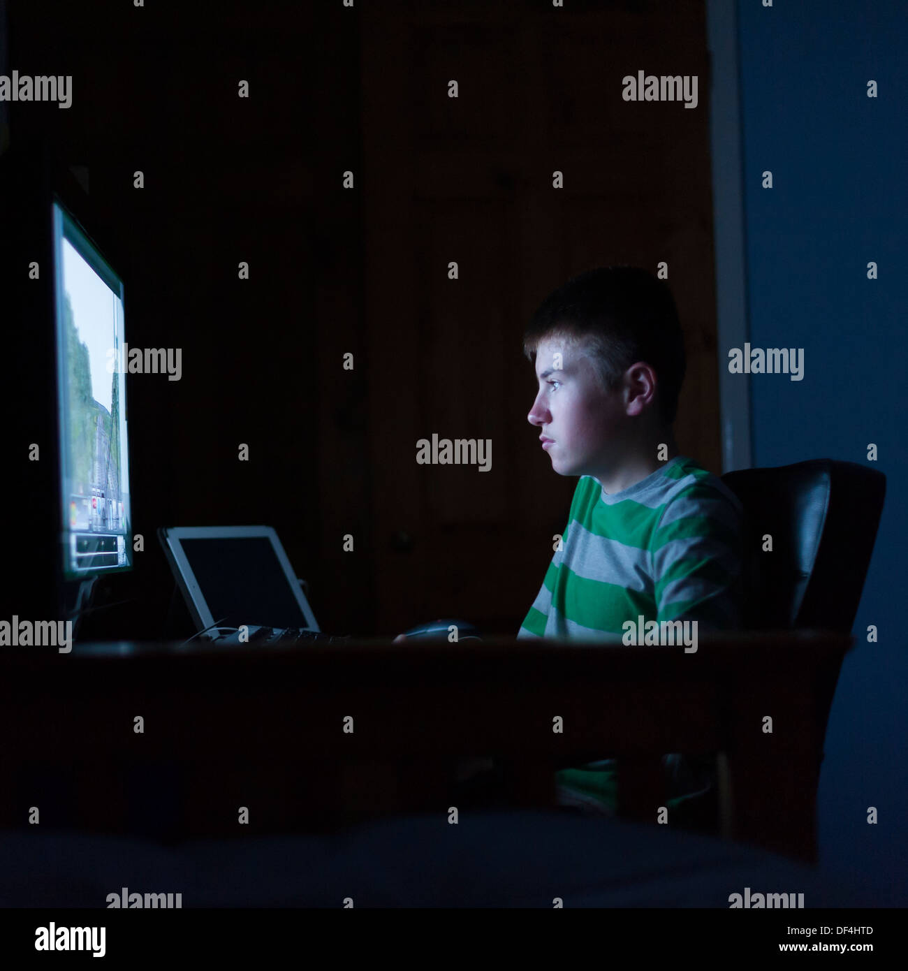 A 13 year old boy looking at his computer screen in his bedroom Stock ...