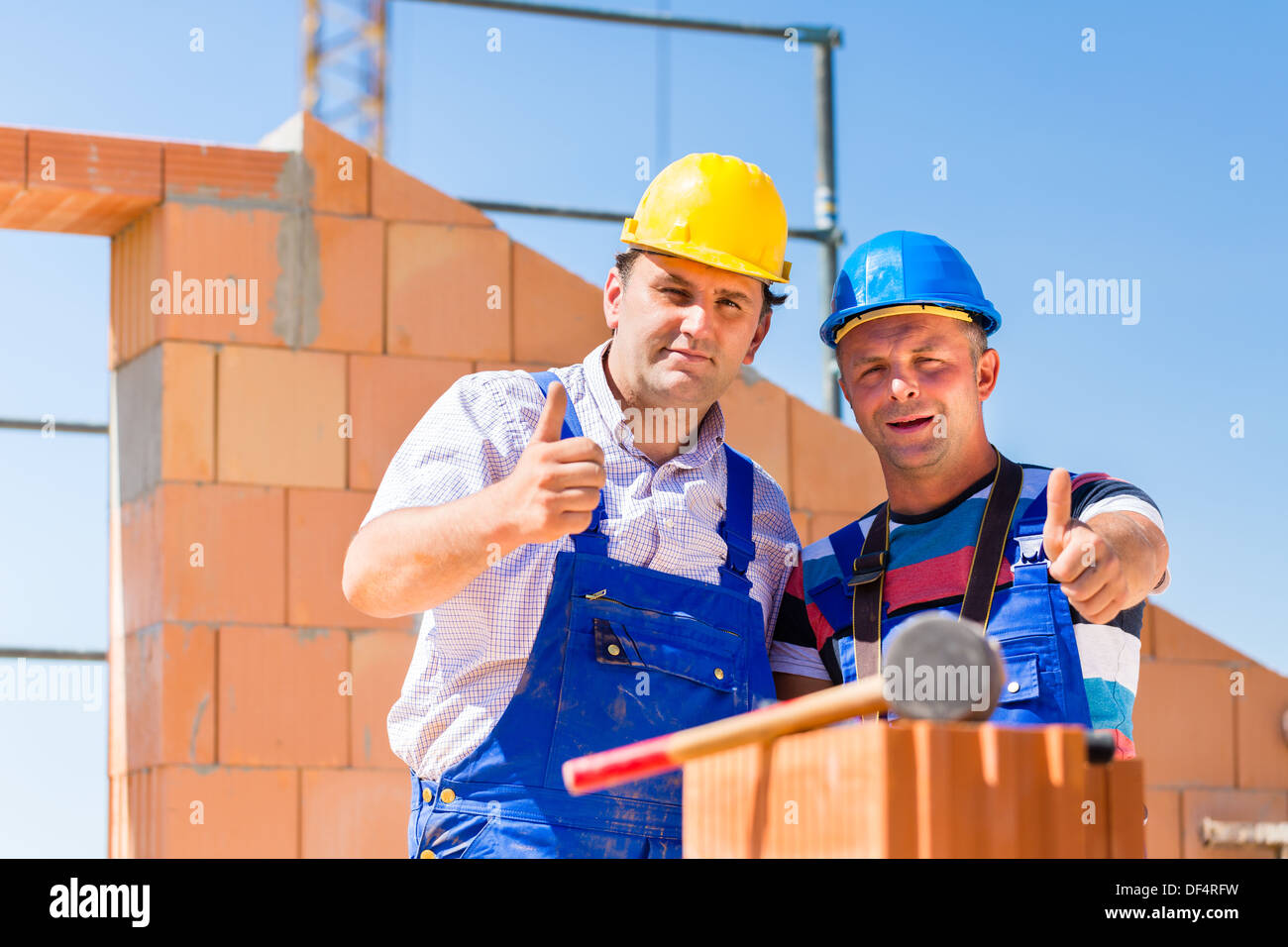 Construction site worker building a home or house doing bricklaying ...