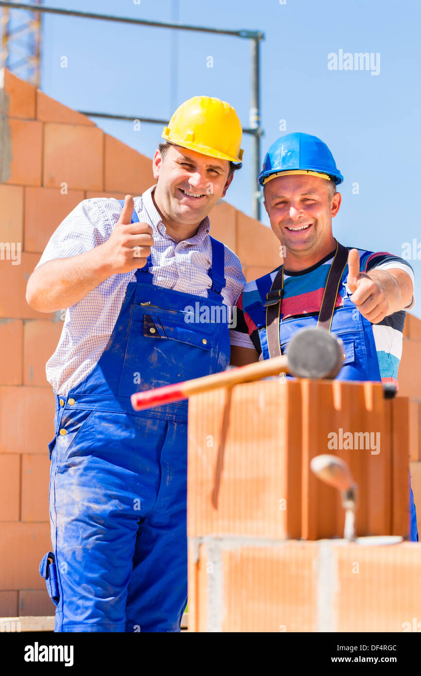 Construction site worker building a home or house doing bricklaying ...