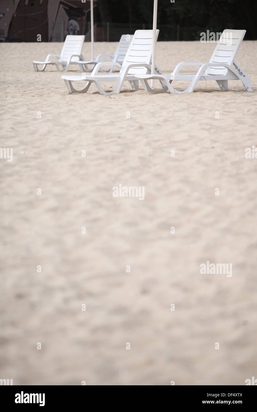 empty white pool plastic chairs deckchairs on sand beach. Vacation ...