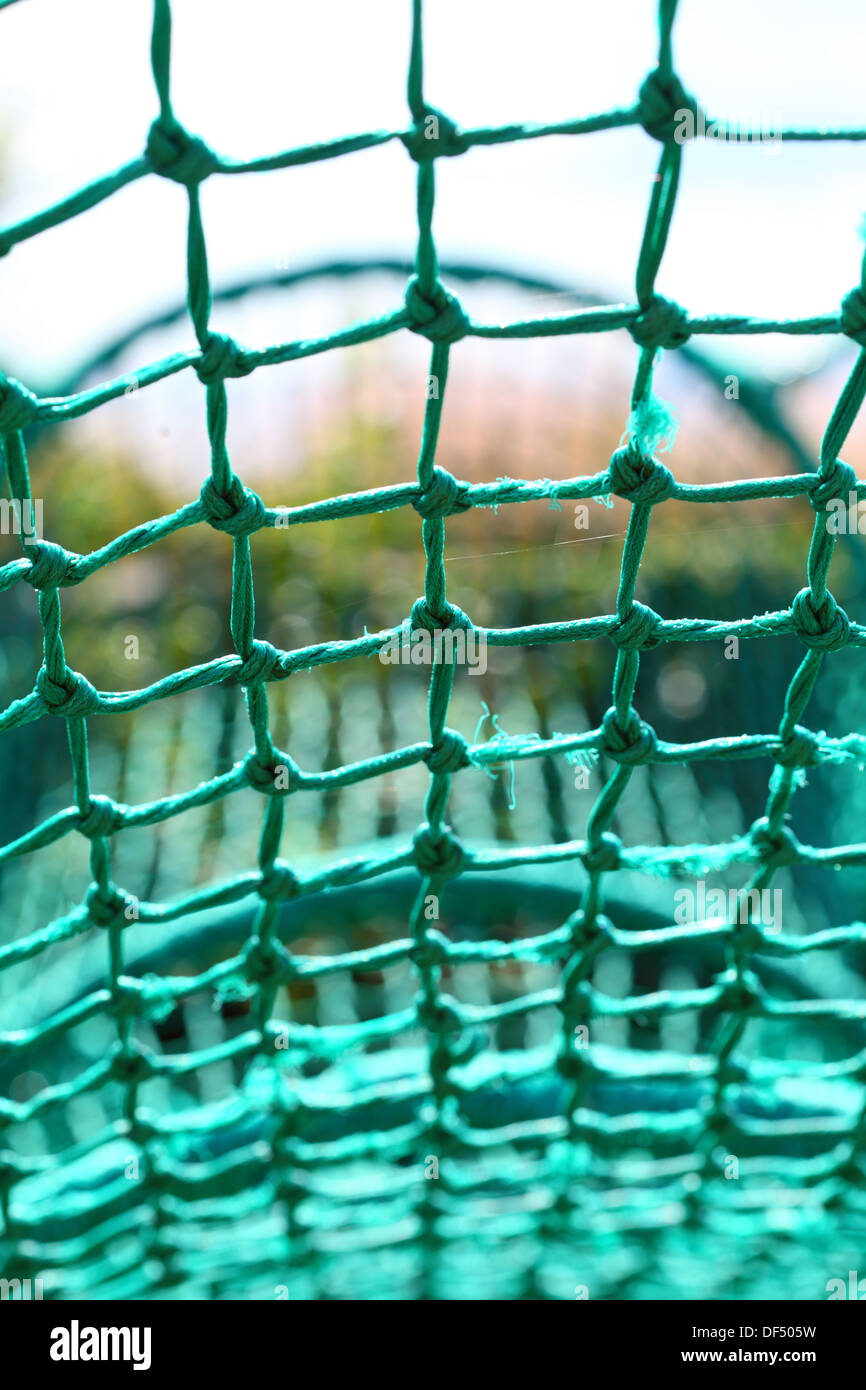Knot rope netting green safety net blurred background Stock Photo - Alamy