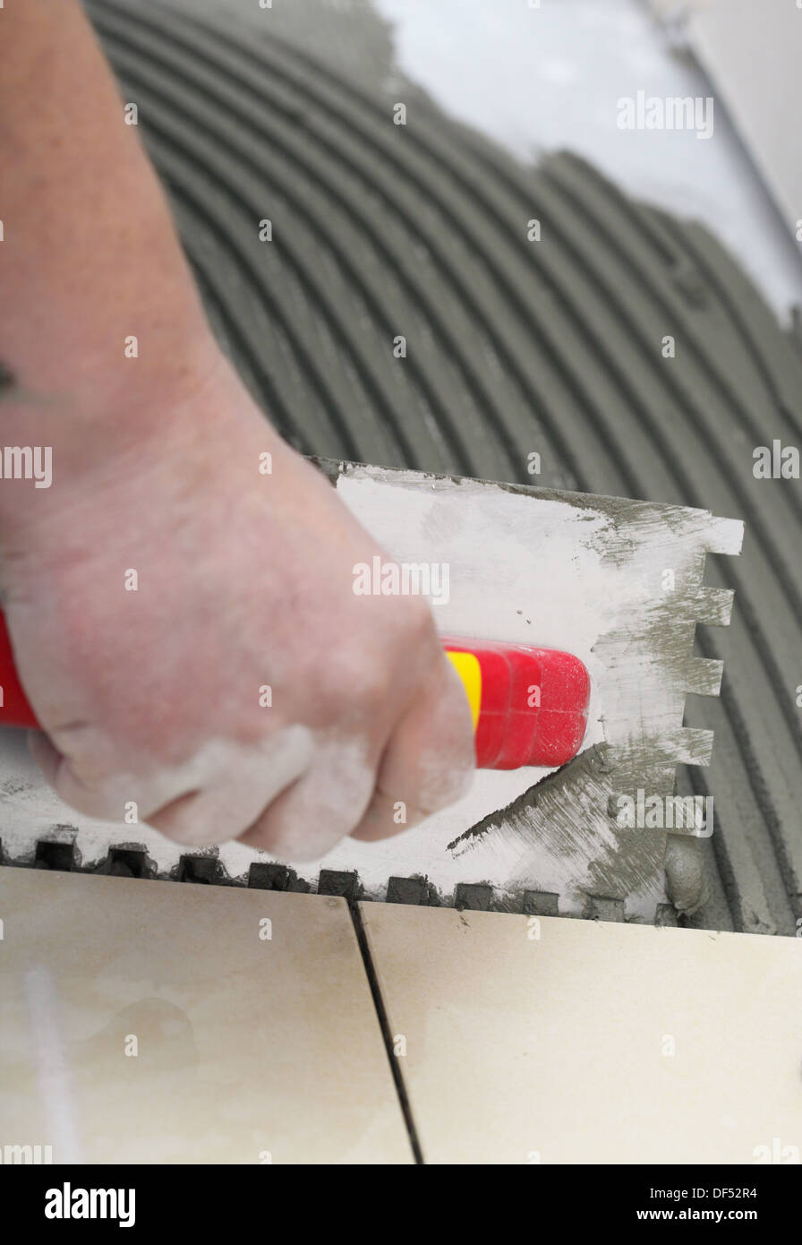 Home improvement, renovation - construction worker tiler is tiling ...