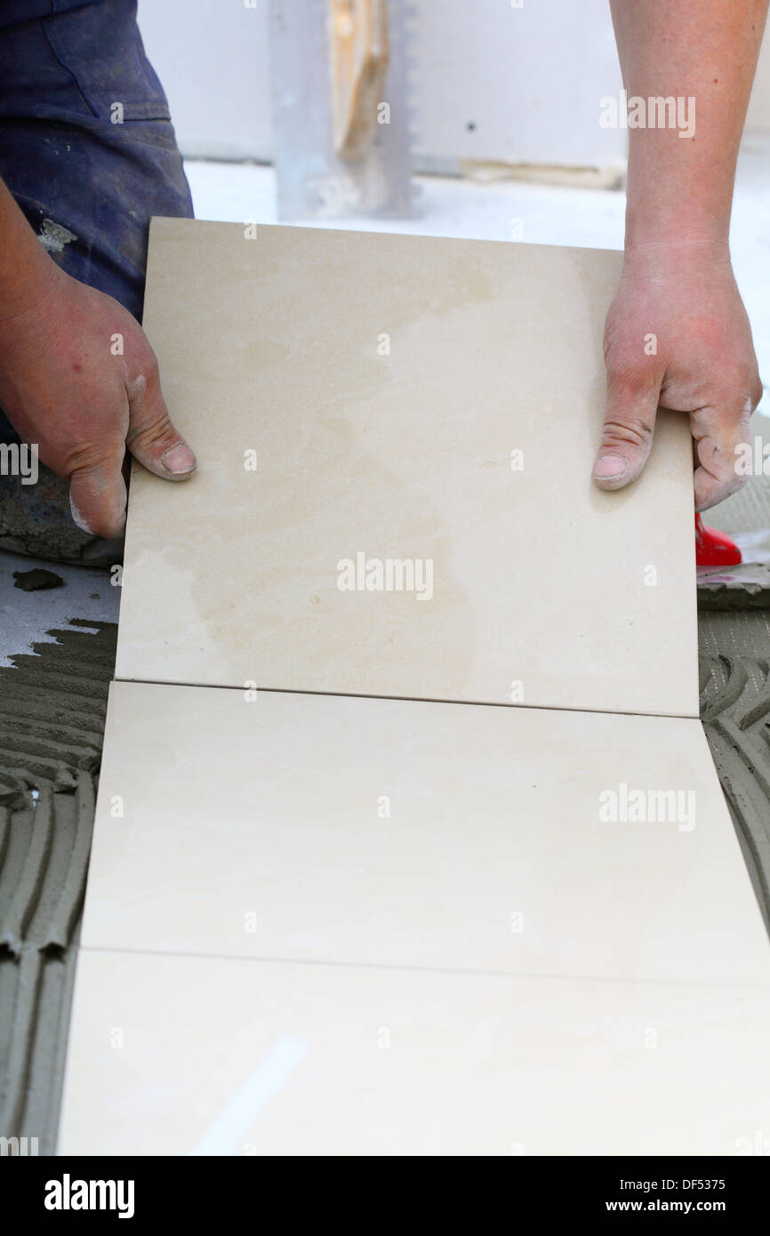 Home improvement, renovation - construction worker tiler is tiling ...