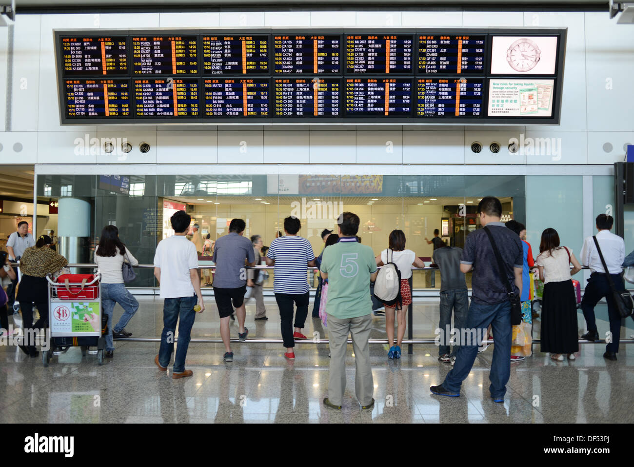 Peoples checking arrival board at airport Stock Photo - Alamy