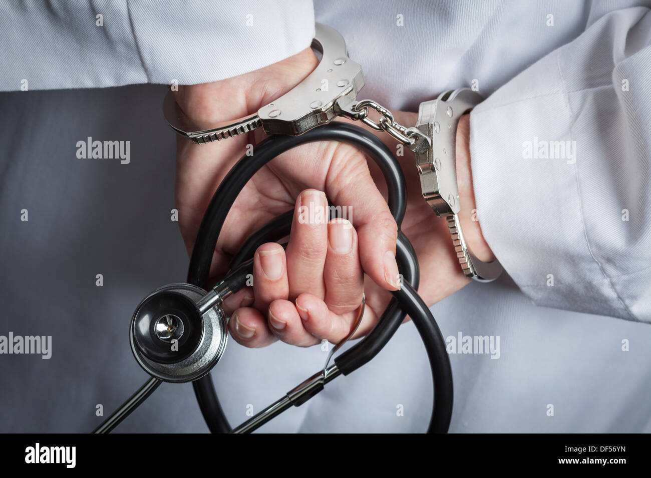 Female Doctor or Nurse In Handcuffs and Lab Coat Holding Stethoscope ...