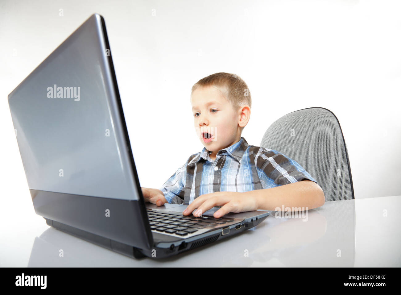 Computer addiction emotional child boy with laptop notebook playing ...