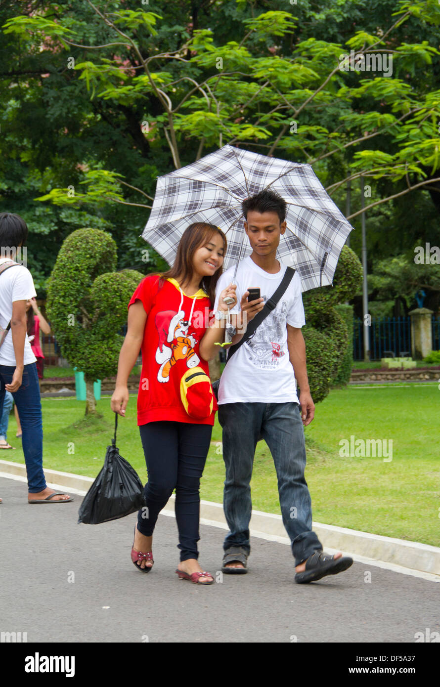 A burmese couple walk through Mahabandoola Garden Park in Yangon, Burma ...