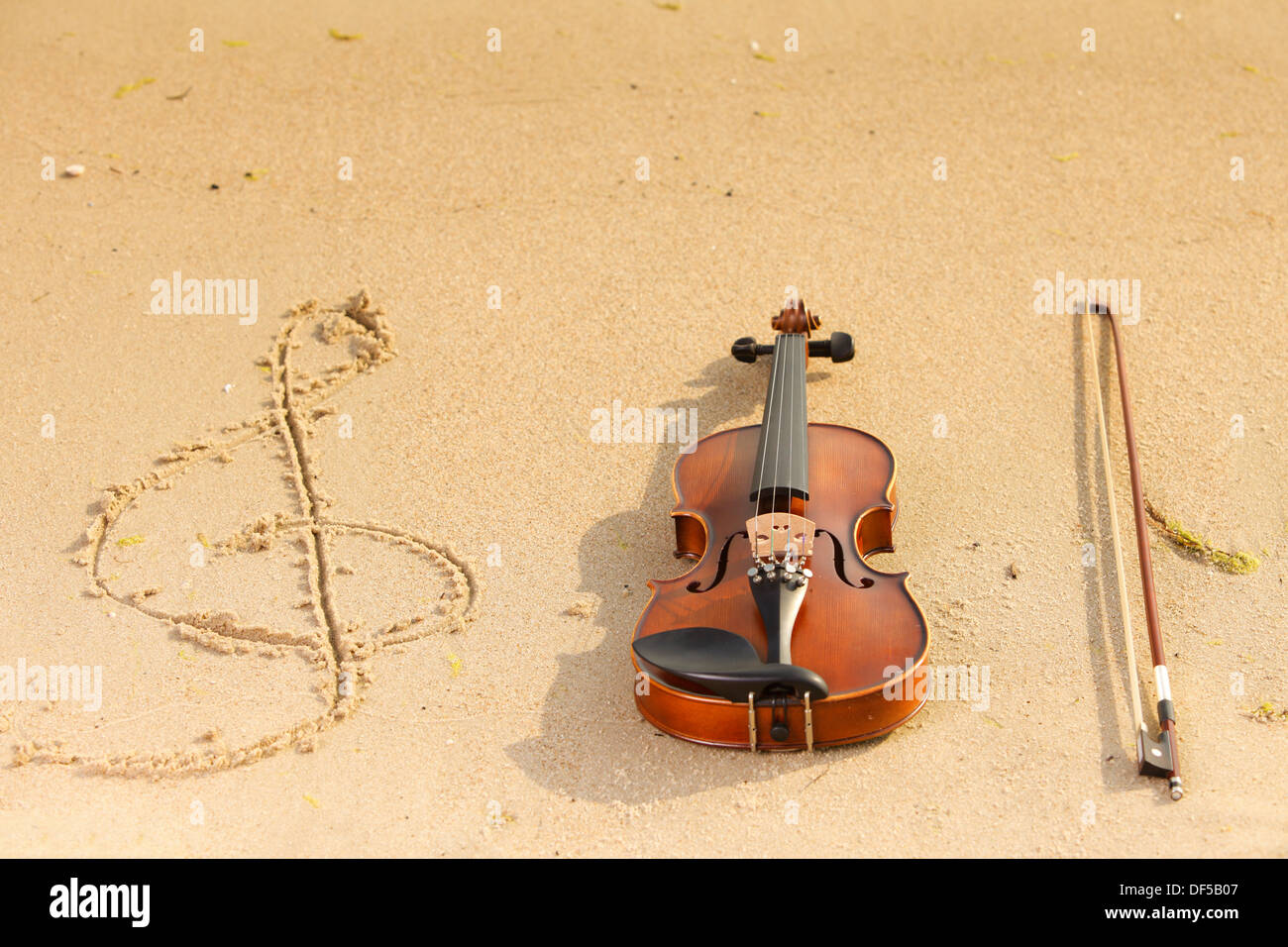 Violin string and g treble clef shape on sandy beach. Love of music ...