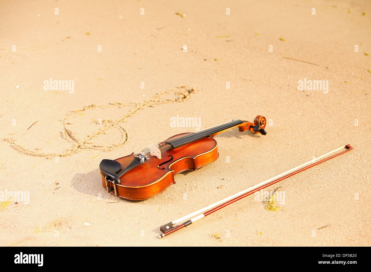 Violin string and g treble clef shape on sandy beach. Love of music ...