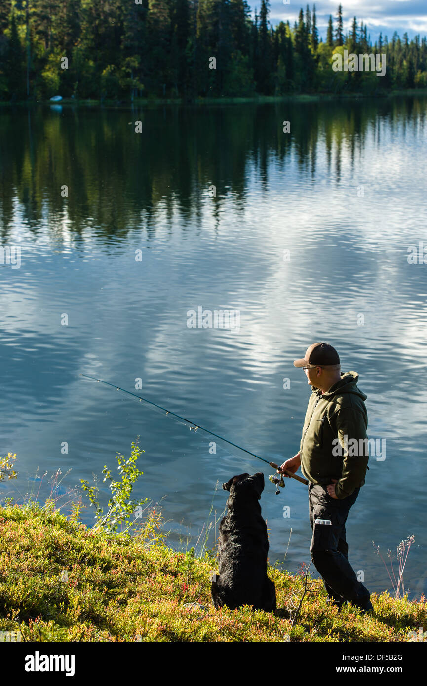 Fisherman and his labrador on the lake Stock Photo - Alamy