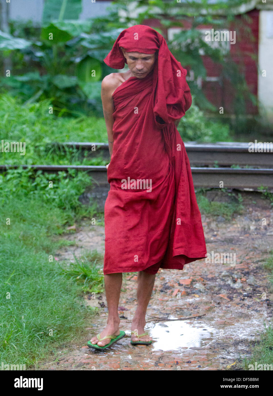 Monk walks near a railway station in yangon hi-res stock photography ...