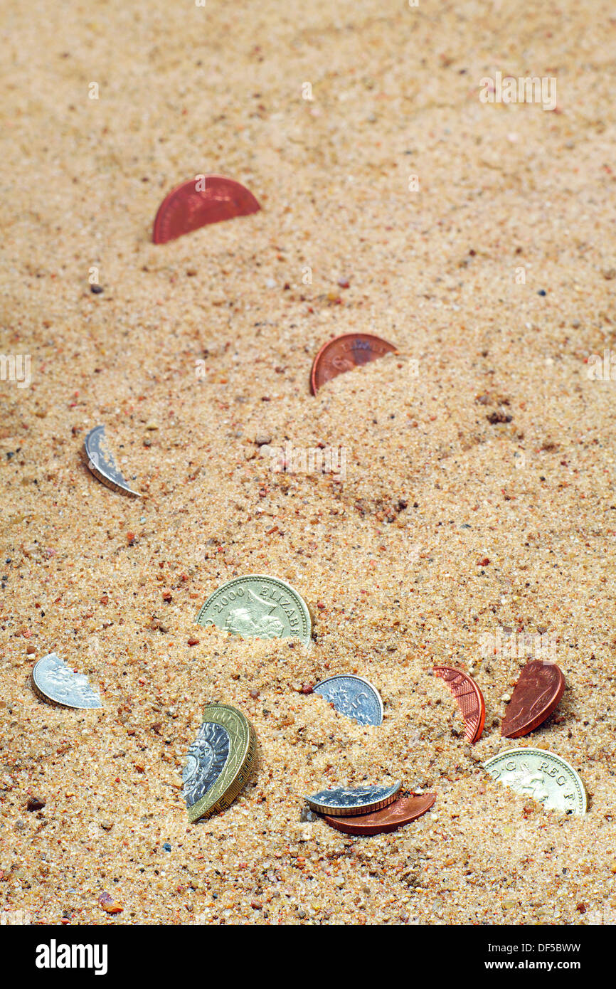 Different coins in the sand Stock Photo - Alamy