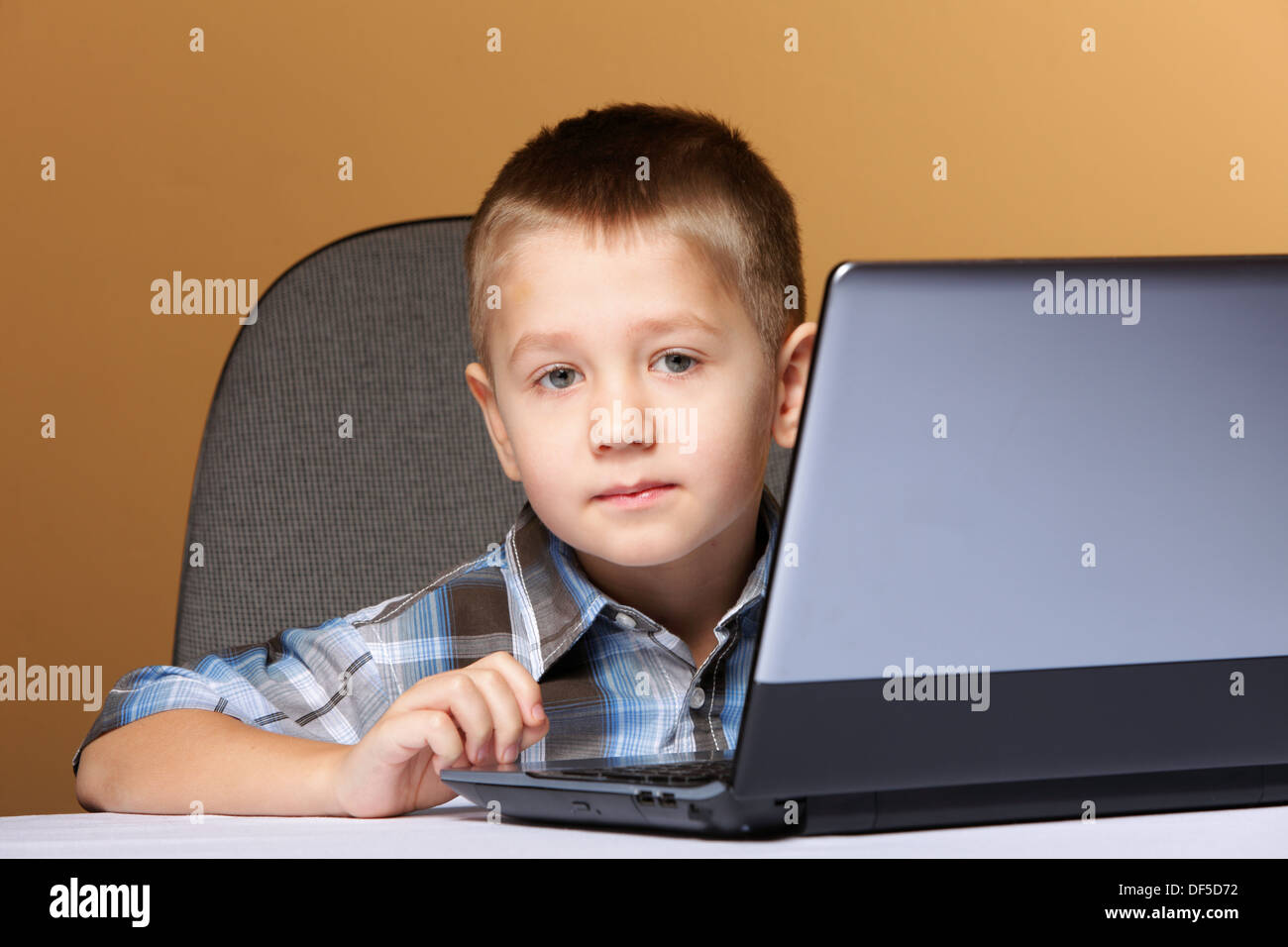 Computer addiction child boy with laptop computer brown background ...